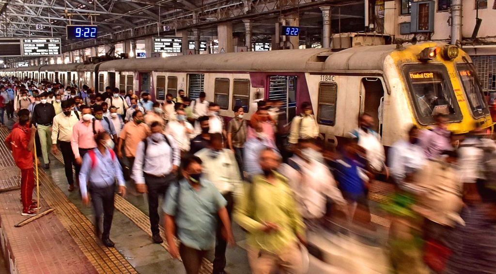 Passengers deboard from a local train at a railway station.