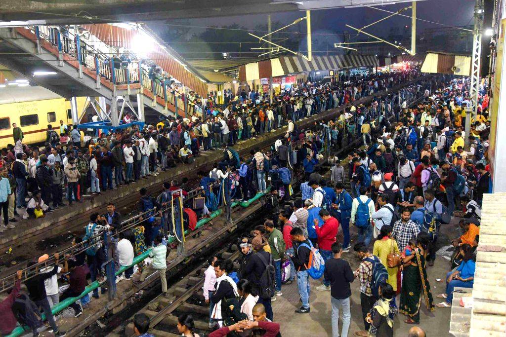 Passengers jostle to board a crowded train