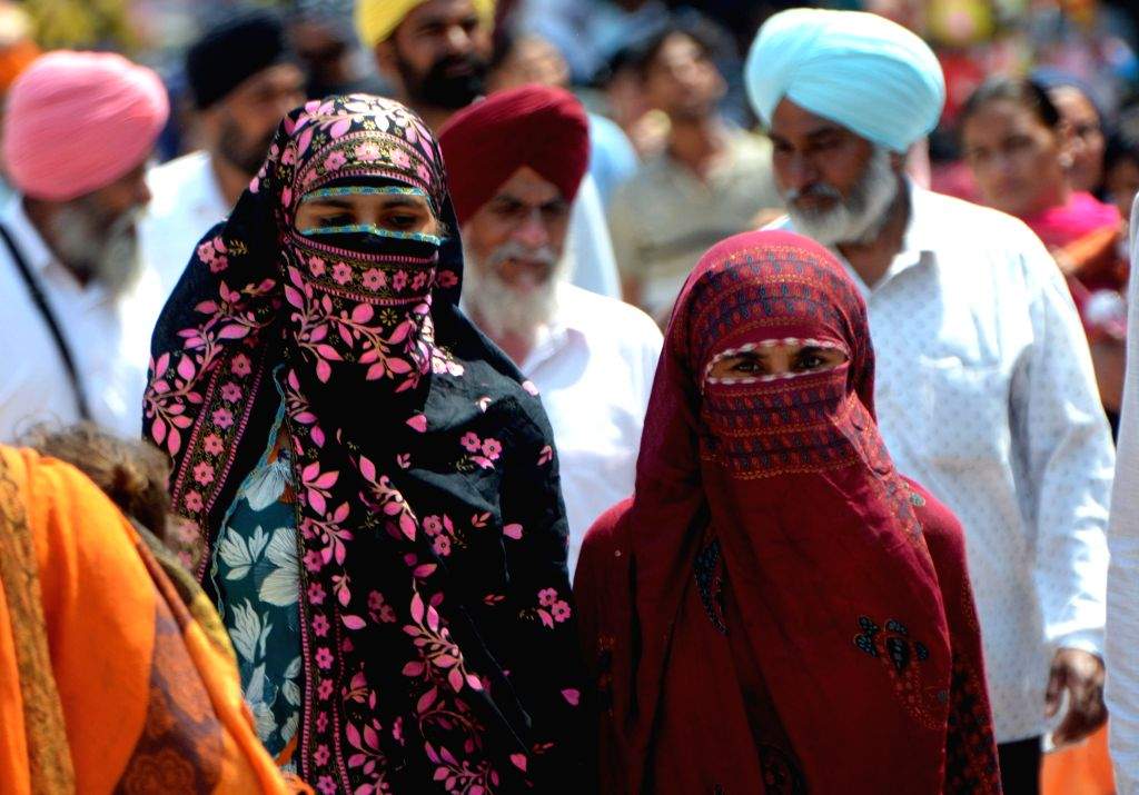 People cover up to protect themselves from scorching heat on a hot ...