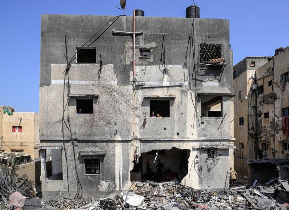 People inspect the rubbles of a house damaged by Israeli airstrike in Gaza