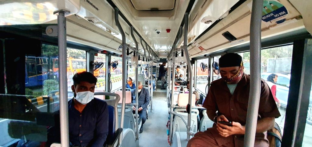 People maintain social distance sit inside a bus