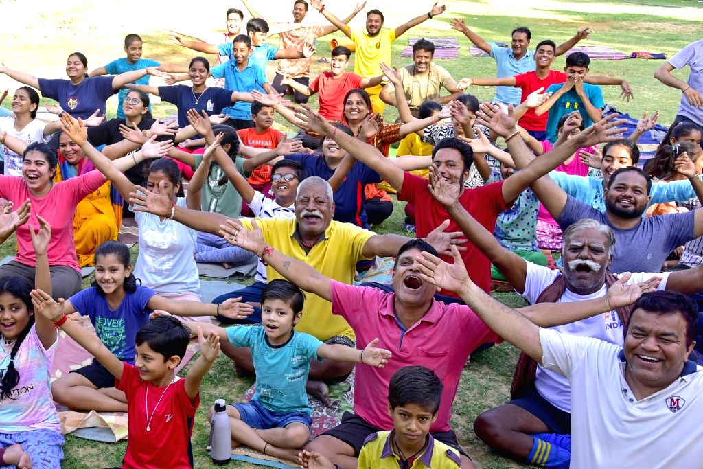 People participate in a laughter exercise ahead of International Yoga Day