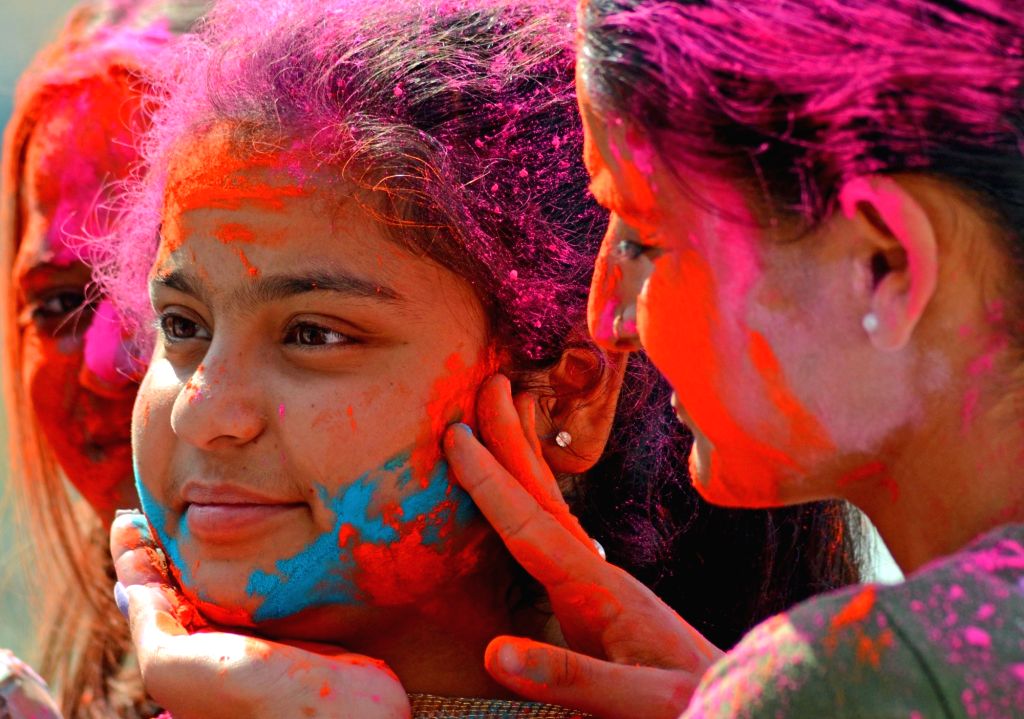 People smeared in colour celebrate Holi festival at Durgiana Temple