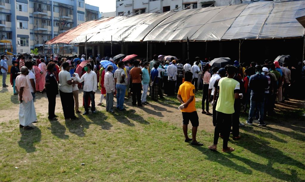 People stand in a queue at a polling station to cast their vote during ...