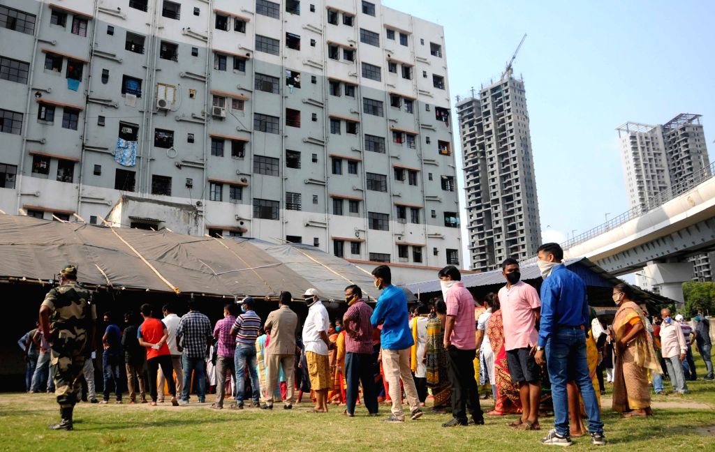 People stand in a queue at a polling station to cast their vote during ...