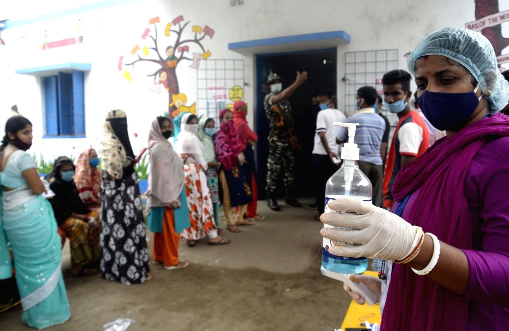 Kolkata : People stand in a queue at a polling station to cast their ...