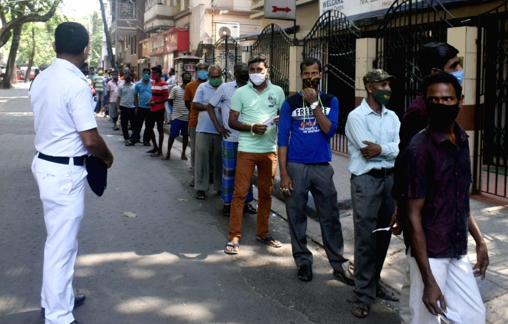People stand in a queue at a polling station to cast their vote at ...
