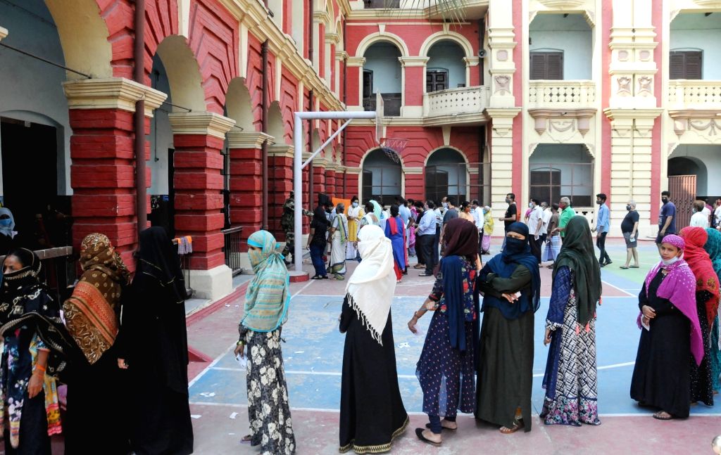 People stand in a queue at a polling station to cast their vote during ...