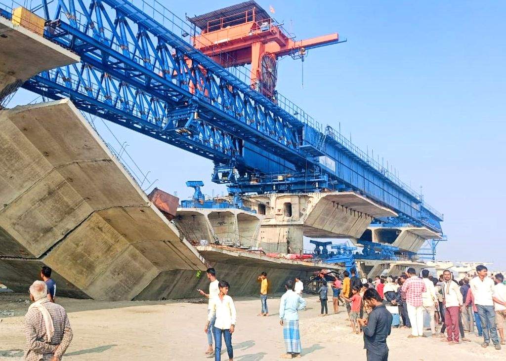 People stand near the collapsed portion of an under-construction bridge ...