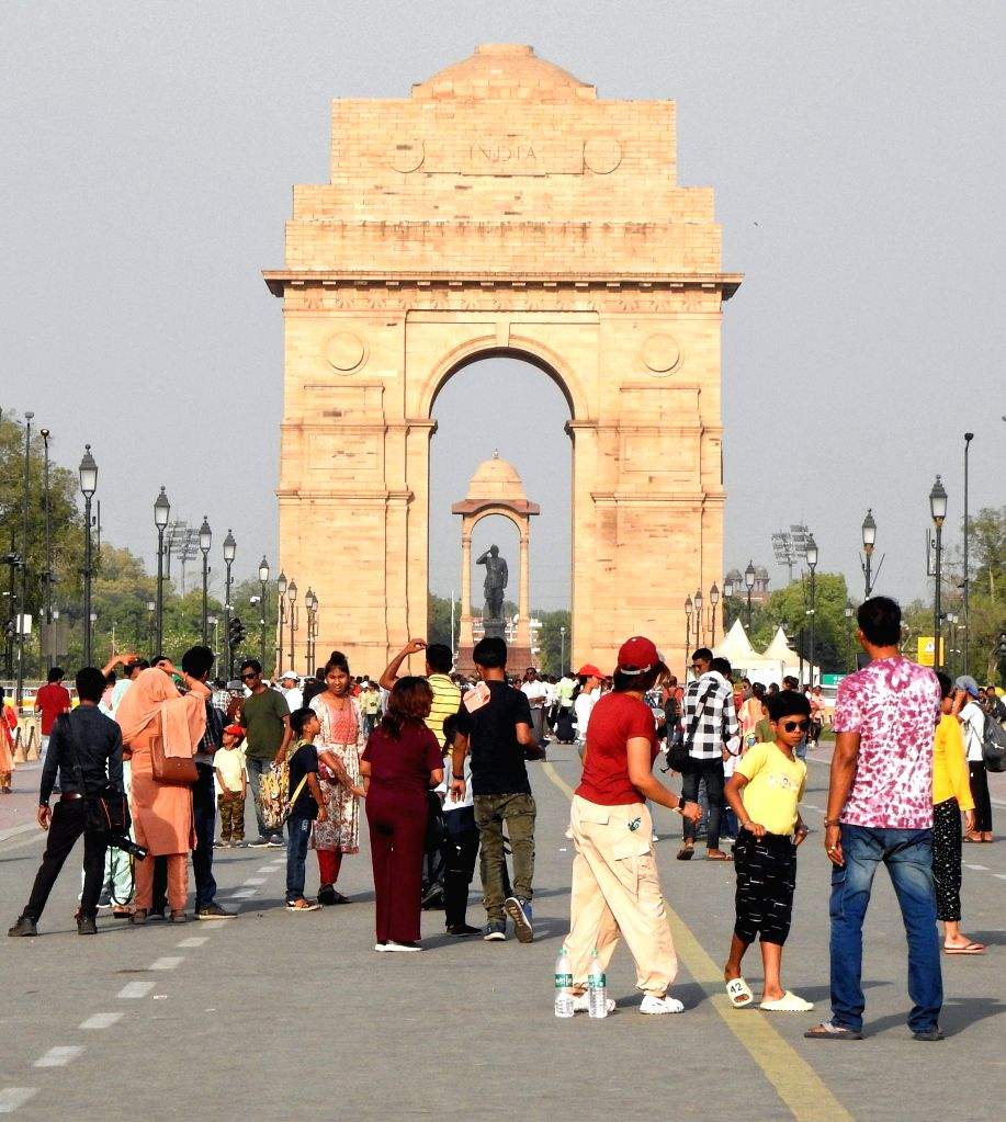 People visit the India Gate on a hot summer day