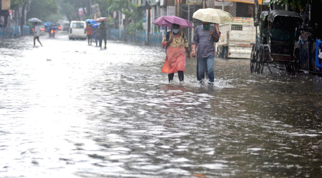 People wade through a Waterlogging road due to heavy rain during ...
