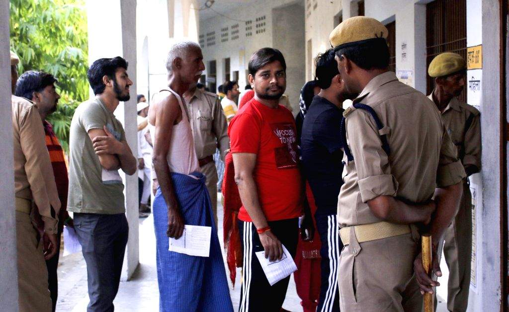 People wait in a queue to cast their votes for the 2nd phase of Lok ...