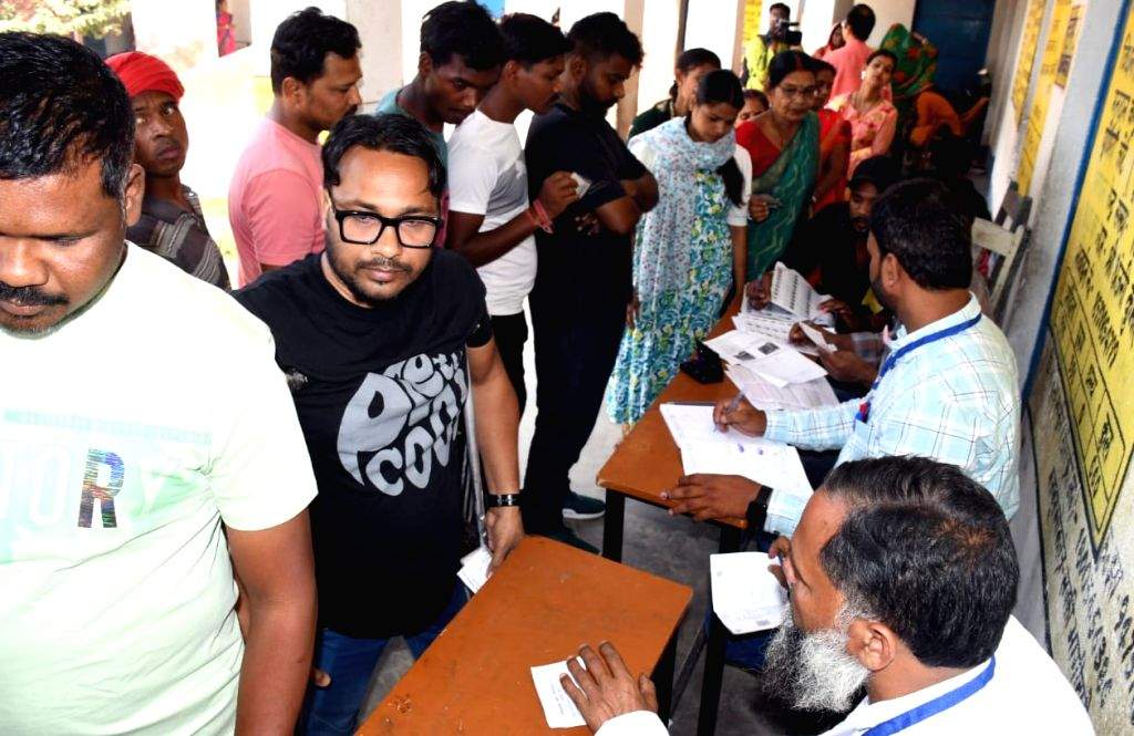 People wait in a queue to cast their votes for the 2nd phase of Lok ...