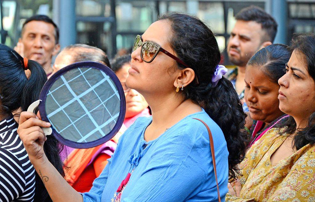 People wait in a queue to cast their votes for the 2nd phase of Lok ...