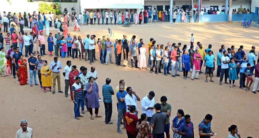 People wait in a queue to cast their votes for the 2nd phase of Lok ...