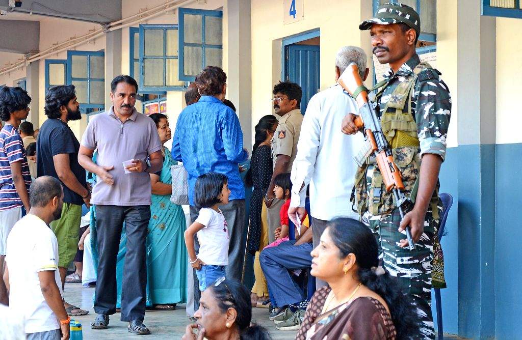 People wait in a queue to cast their votes for the 2nd phase of Lok ...