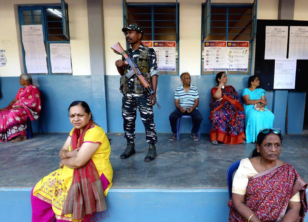 People wait in a queue to cast their votes for the 2nd phase of Lok ...