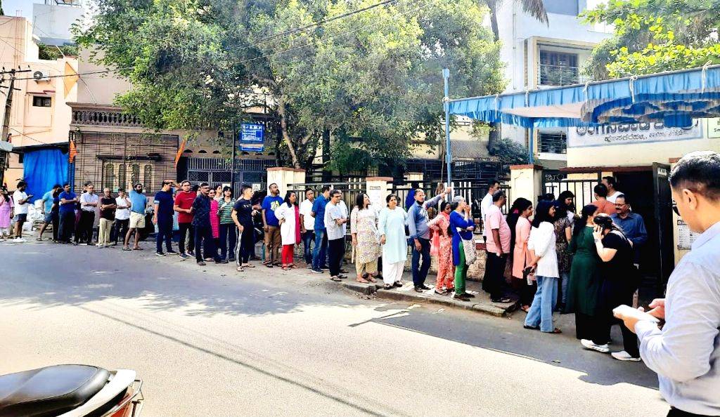 People wait in queues to cast their votes for the 2nd phase of Lok ...