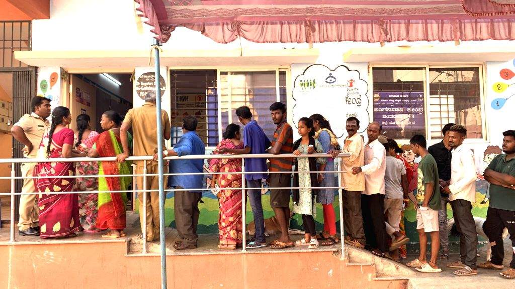 People wait in queues to cast their votes for the 2nd phase of Lok ...