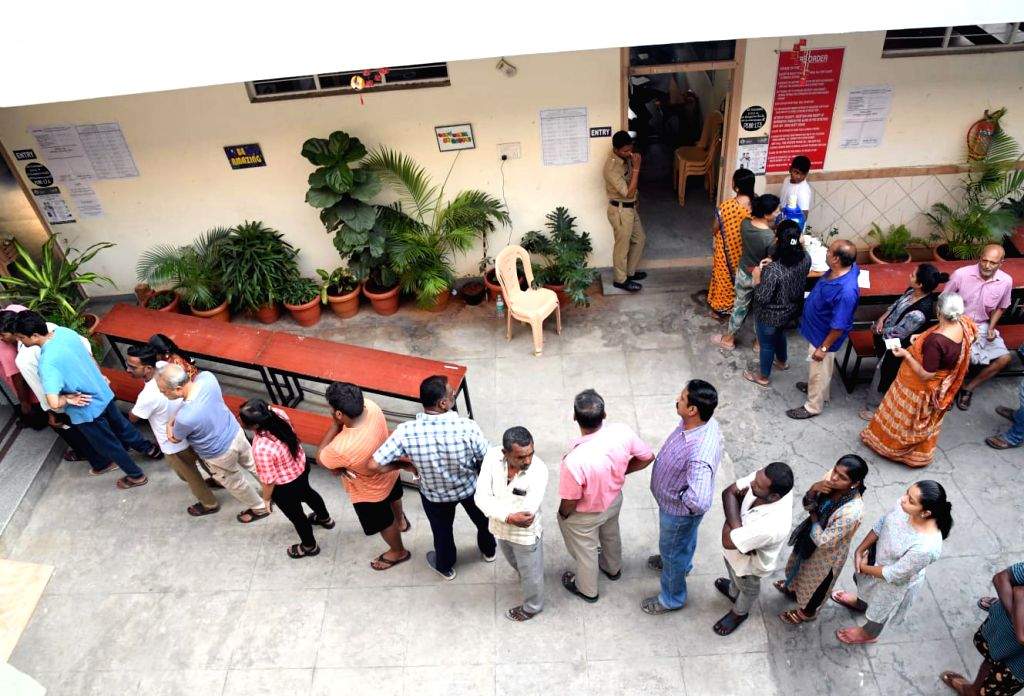 People wait in queues to cast their votes for the 2nd phase of Lok ...