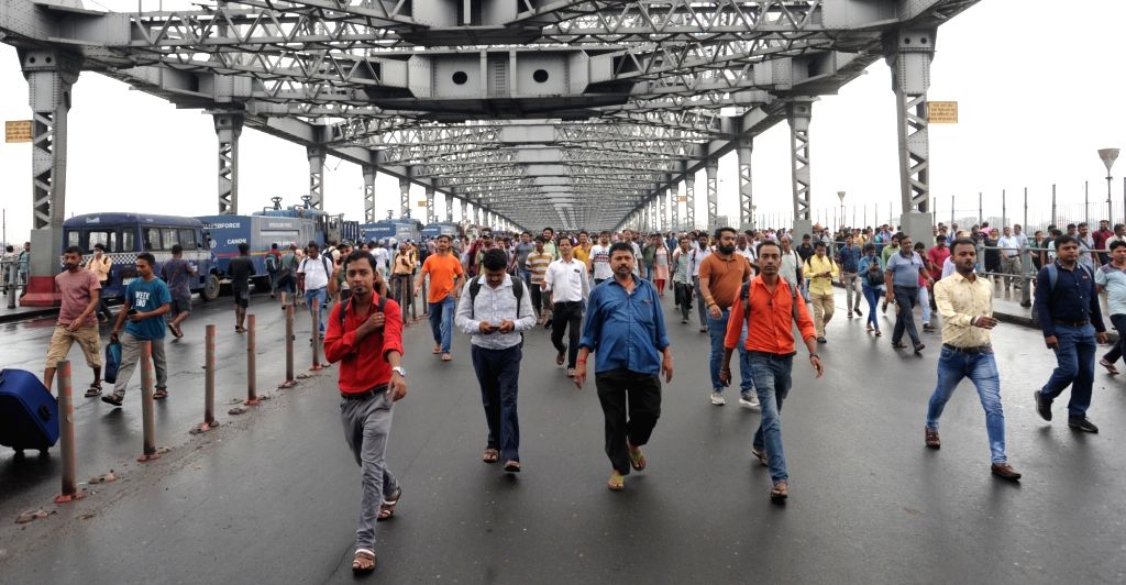 People walk through the Howrah Bridge.