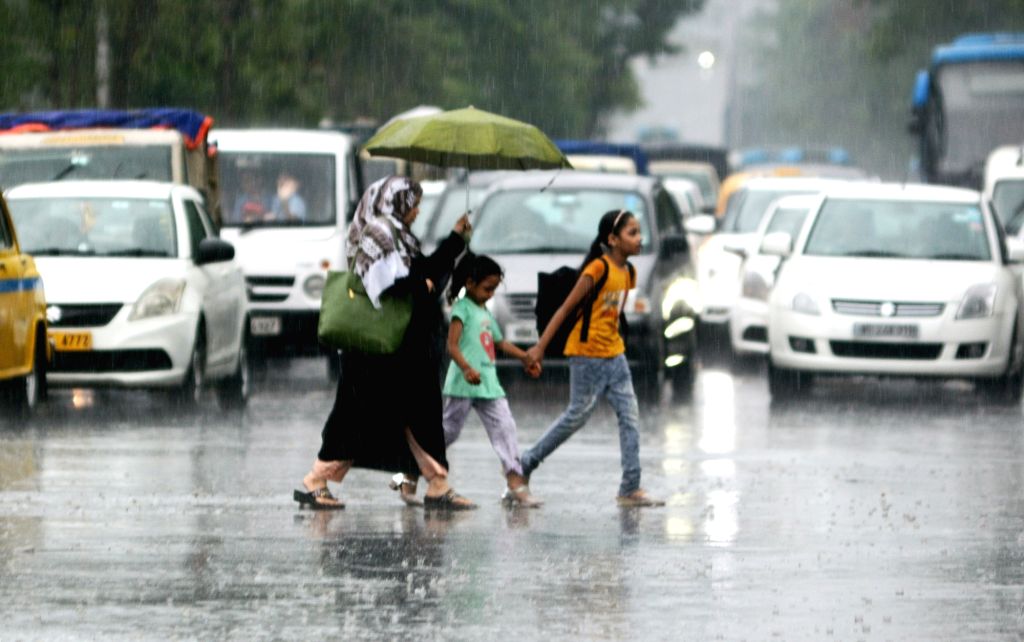 Kolkata : People walk under umbrella to protect themselves from pouring ...