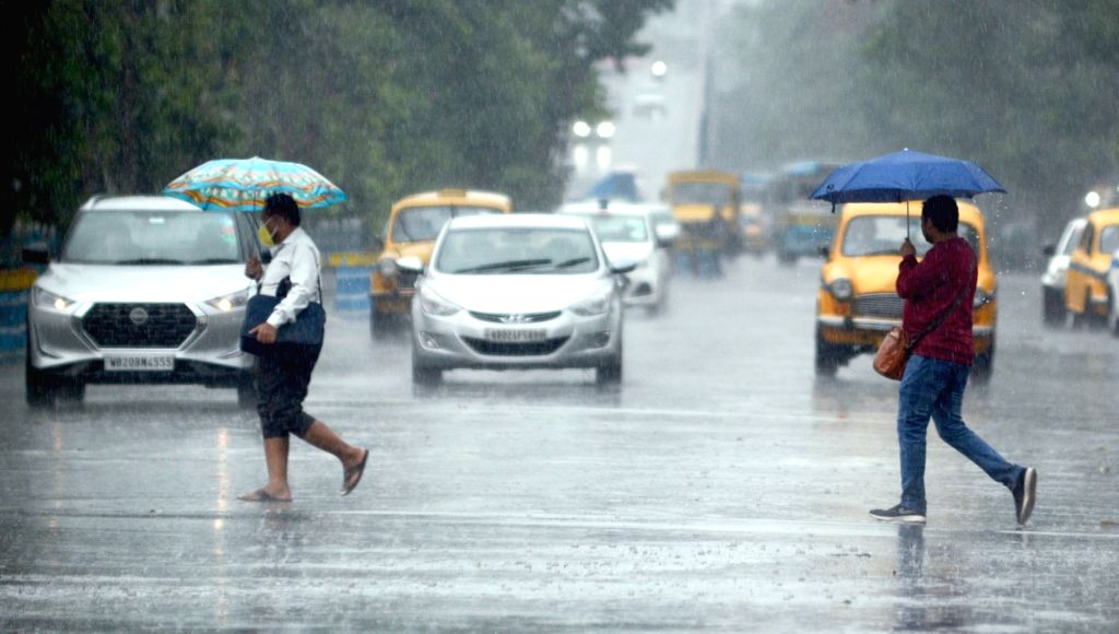 Kolkata : People walk under umbrella to protect themselves from pouring ...