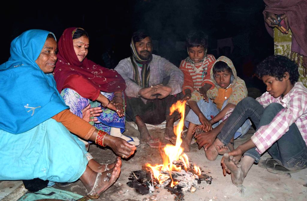People warm themselves around a fire