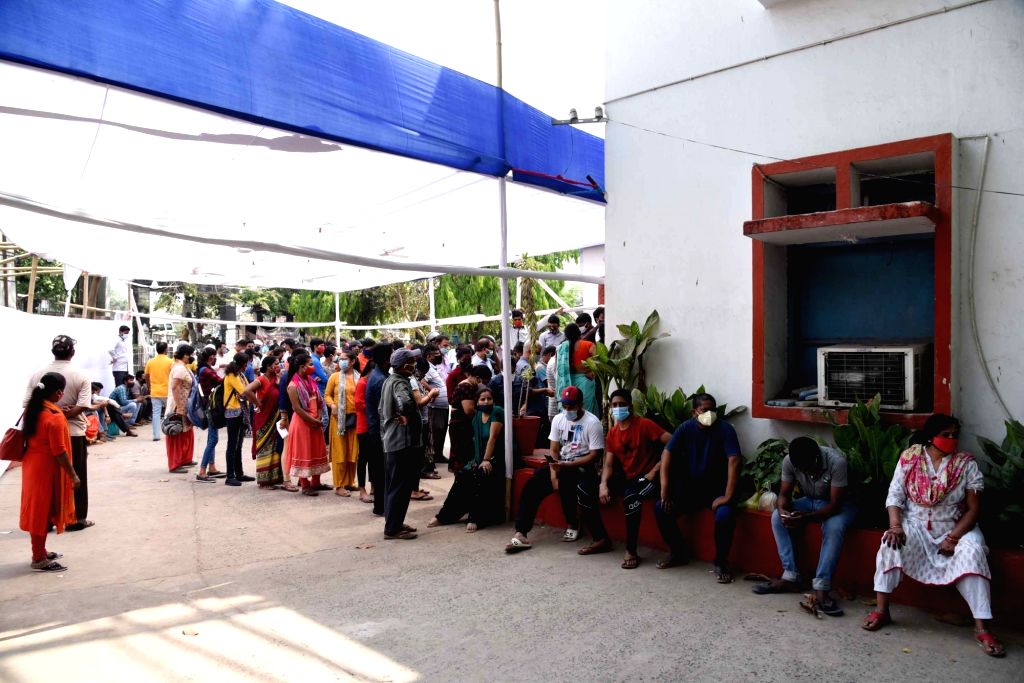 Peoples ignoring social distance stand in a queue to register their ...