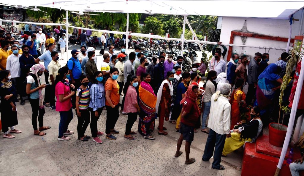 Peoples ignoring social distance stand in a queue to register their ...