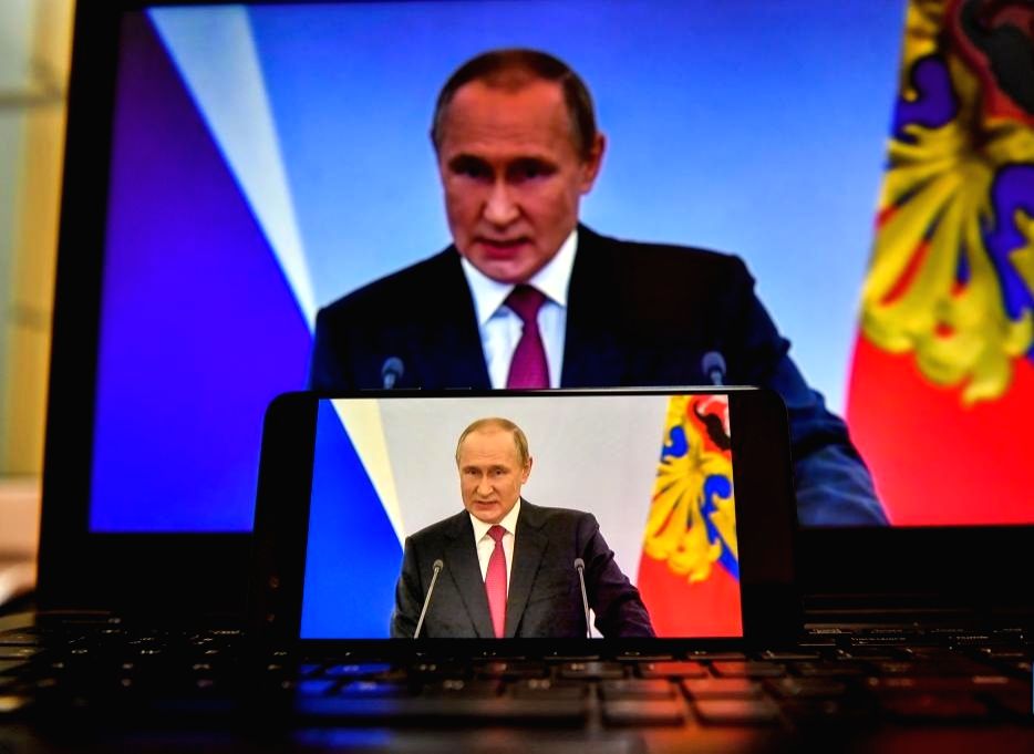 Screens displaying Russian President Vladimir Putin delivering a speech ...