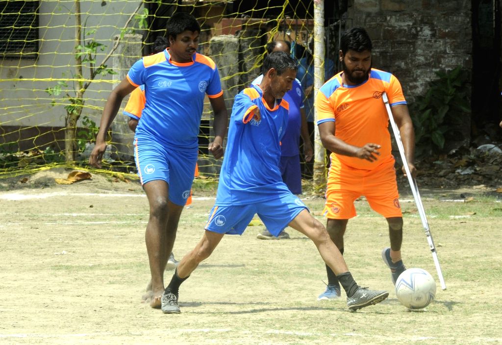 Physically challenged people play football during an event