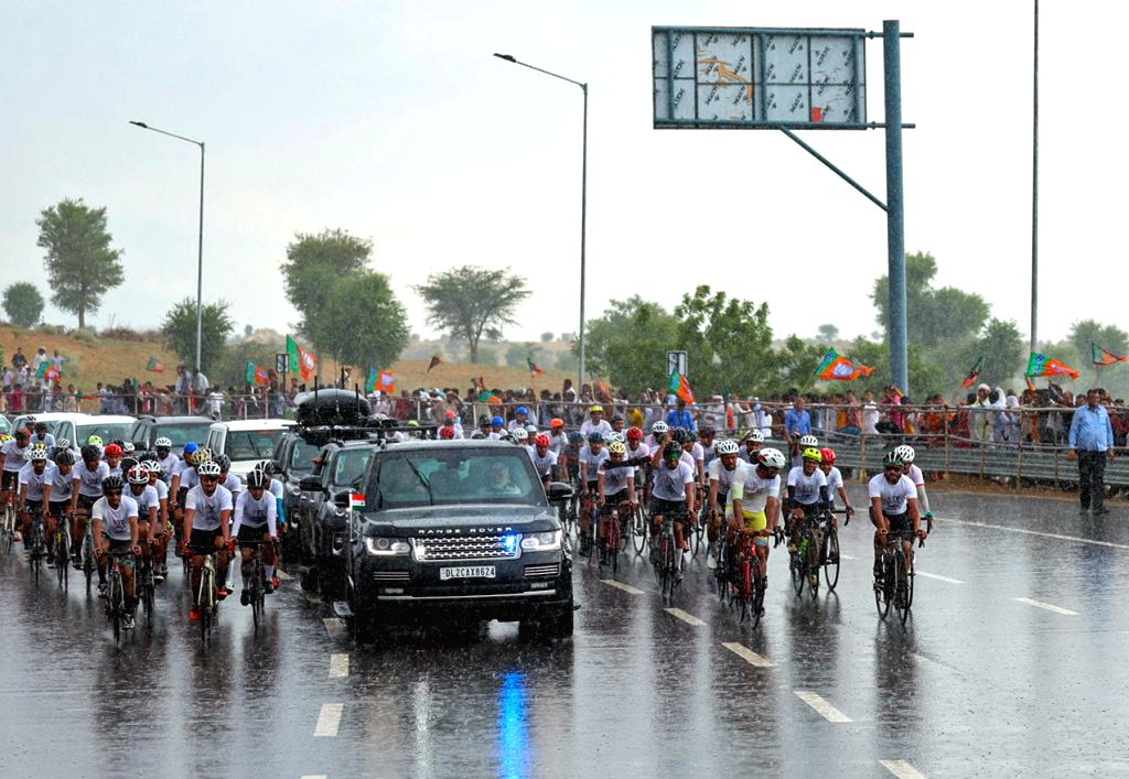 PM Modi's convoy rides along a platoon of cyclists during the roadshow ...