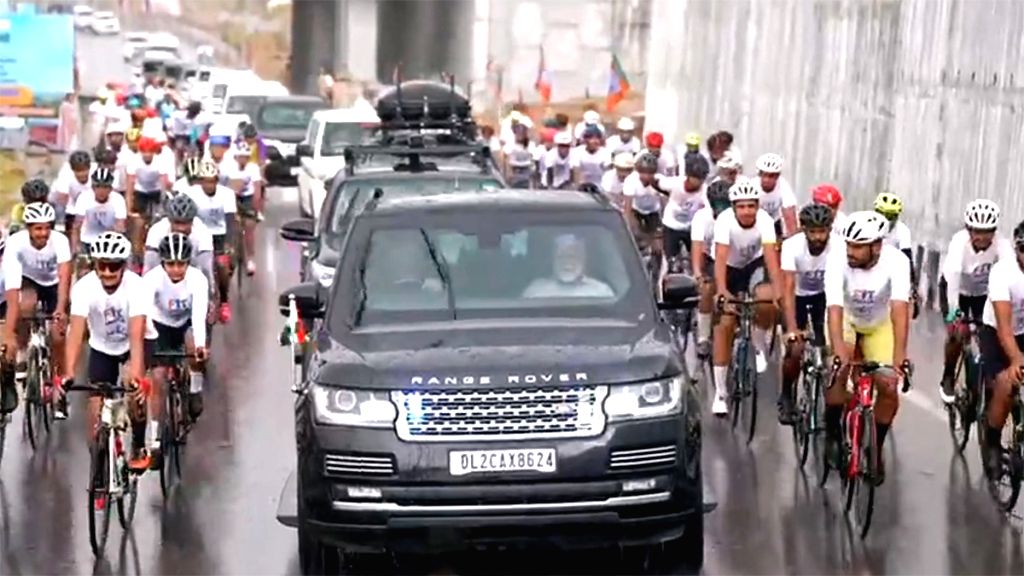 PM Modi's convoy rides along a platoon of cyclists during the roadshow ...