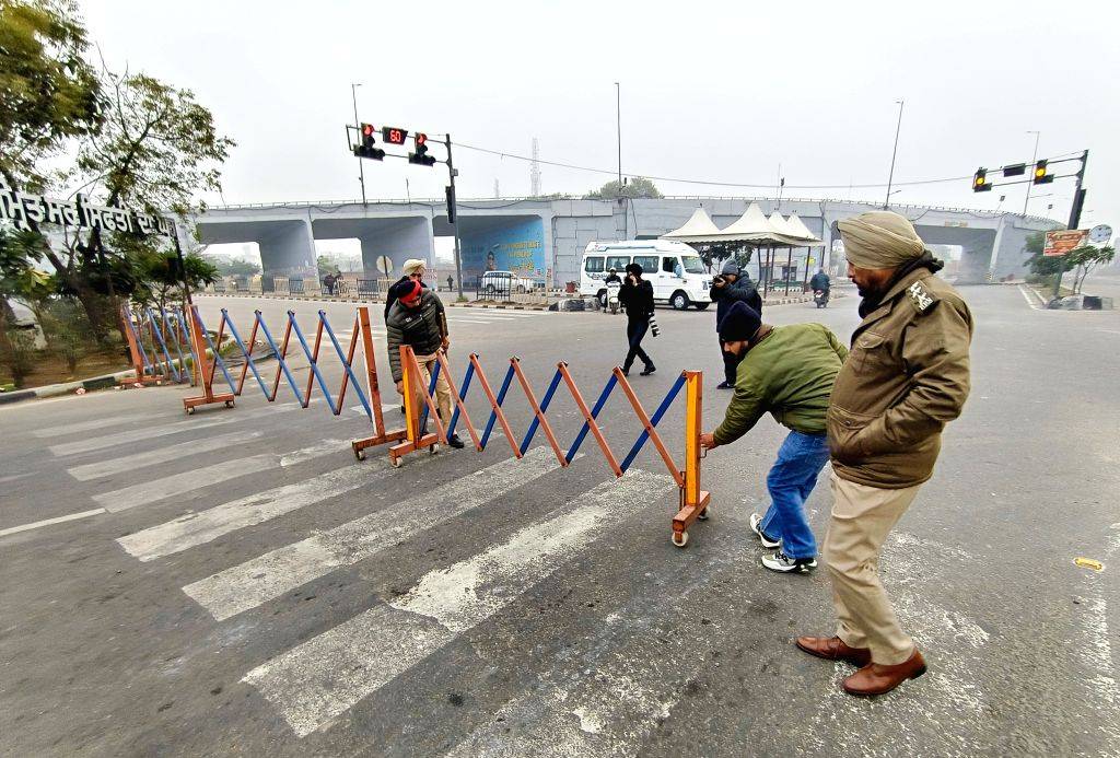 Police personnel block a road with barricades as farmers stage a ...
