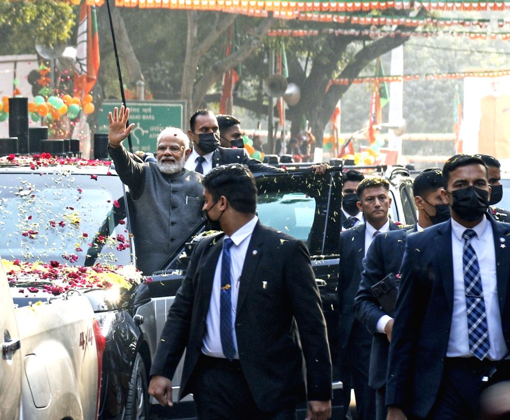 Prime Minister Narendra Modi waves to supporters during a roadshow