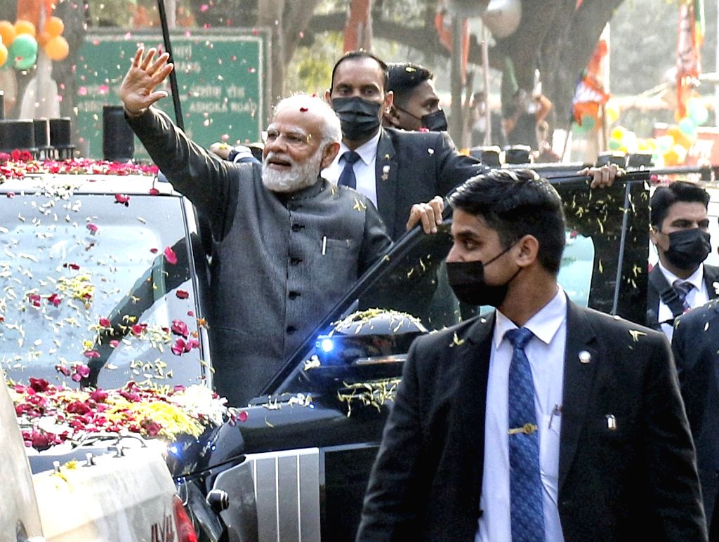 Prime Minister Narendra Modi waves to supporters during a roadshow