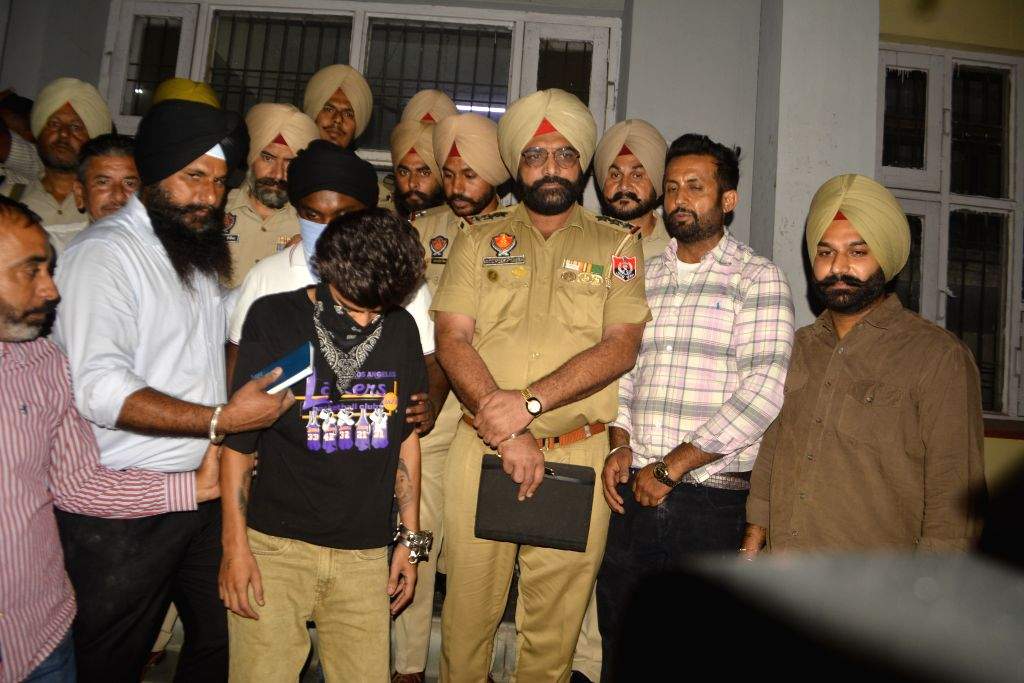 Punjab Police officials bring recovered heroin and two associates ...