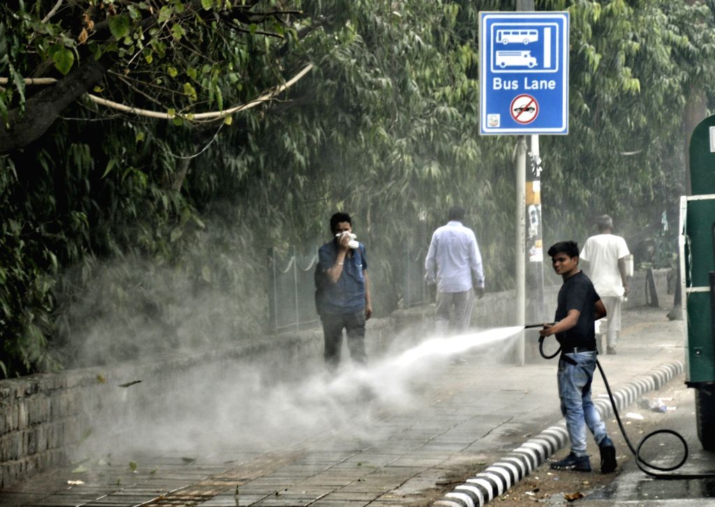 PWD worker sprays water sprinkle through a anti-smog gun