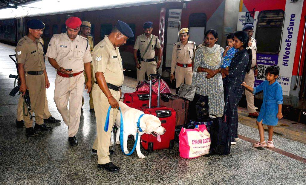 Railway Police Force (RPF) personnel with a sniffer dog inspect a ...
