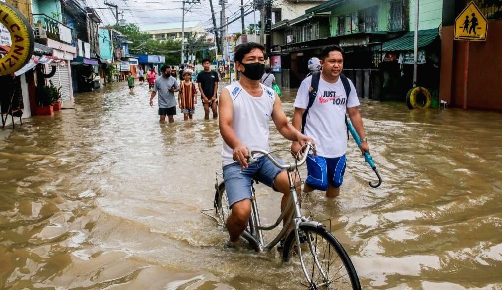 Residents wade through the flood in Cavite Province, the Philippines ...