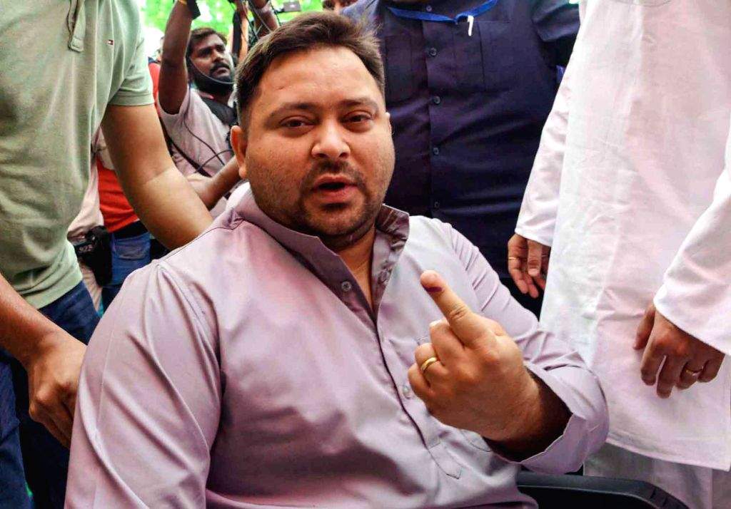 RJD leader Tejashwi Yadav shows his finger marked with indelible ink ...