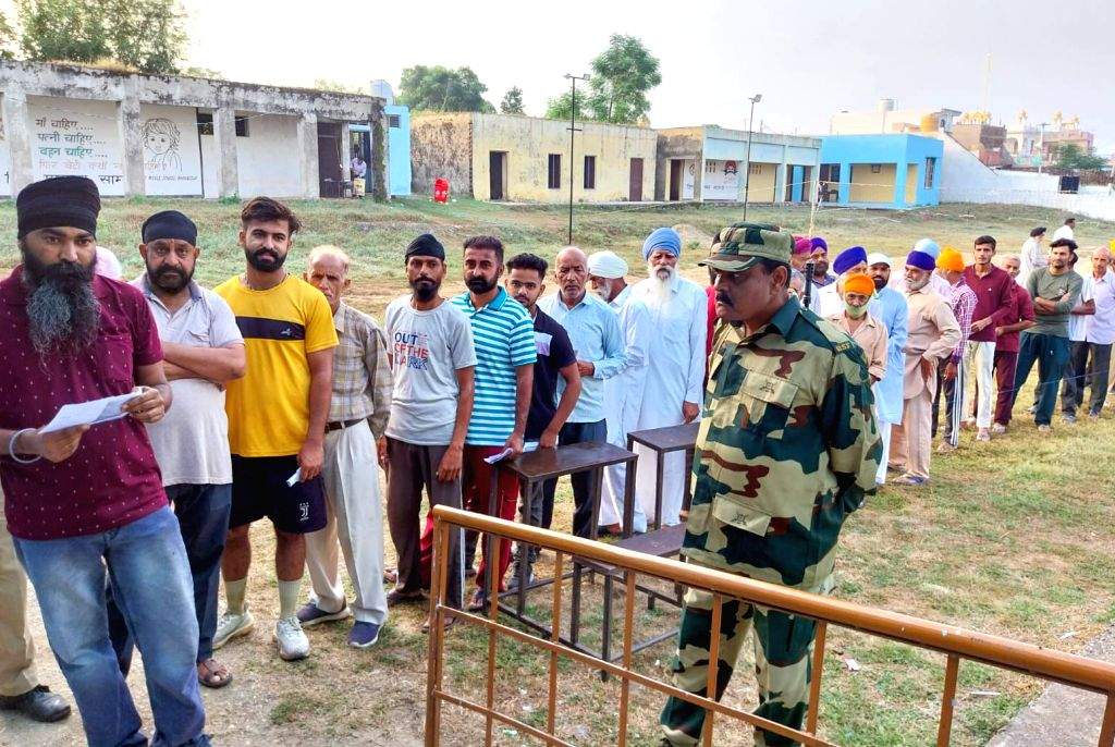 Samba : Voters line up at a polling booth during the third phase of J&K ...