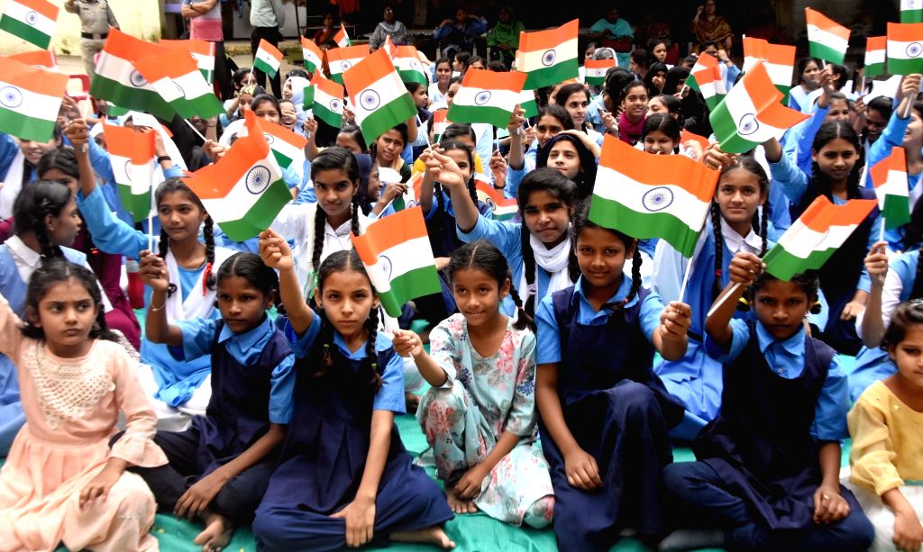 : Bhopal: School children hold national flags which are being ...