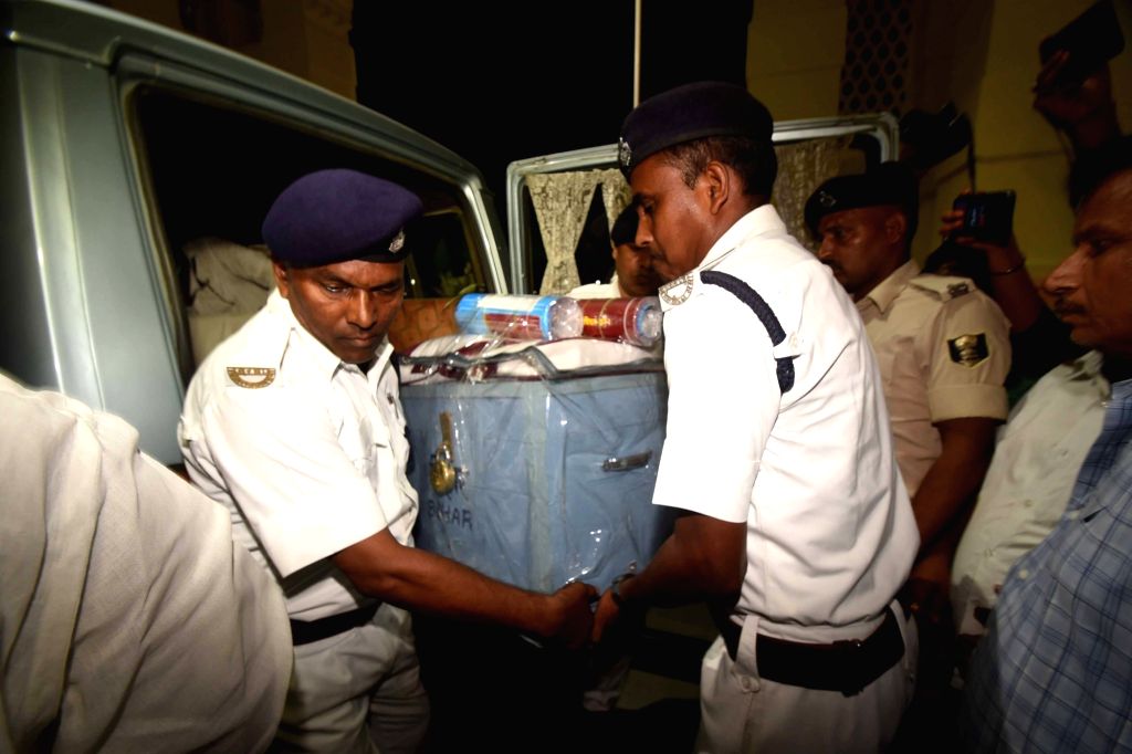 Security personnel carry ballot boxes and other election material.