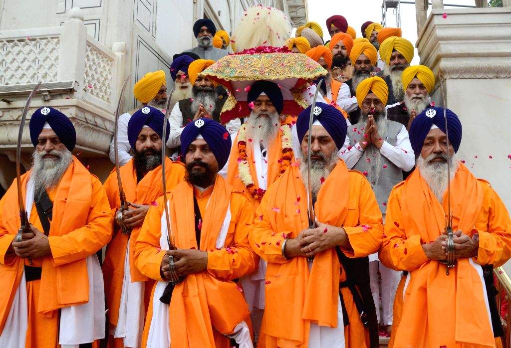 Sikh devotees carry the Guru Granth Sahib (Sikh holy book) during the ...