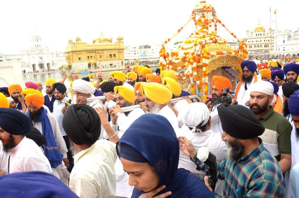 Sikh devotees carry the Guru Granth Sahib (Sikh holy book) during a ...