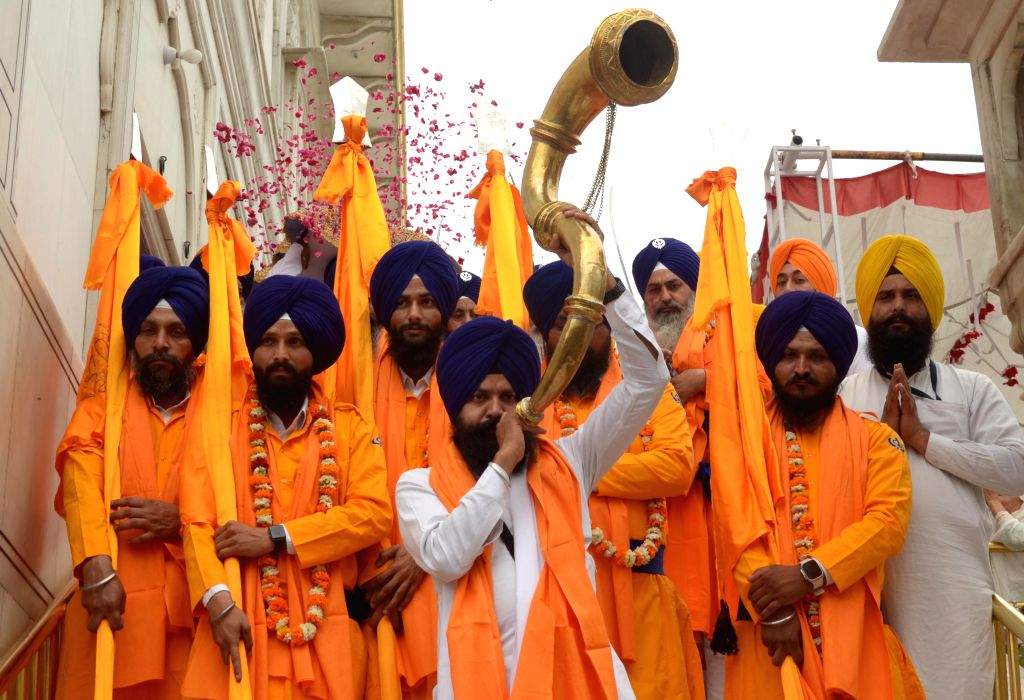 Sikh devotees carry the Guru Granth Sahib (Sikh holy book) during a ...