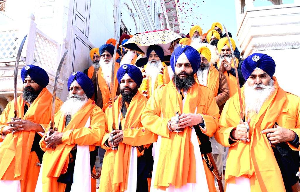 Sikh devotees carry the Guru Granth Sahib (Sikh holy book) during a ...