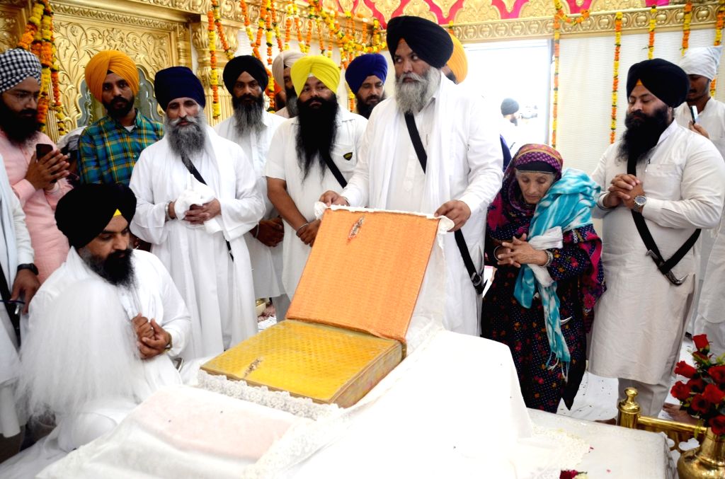 Sikh priests display a copy of Guru Granth Sahib that is said to have ...